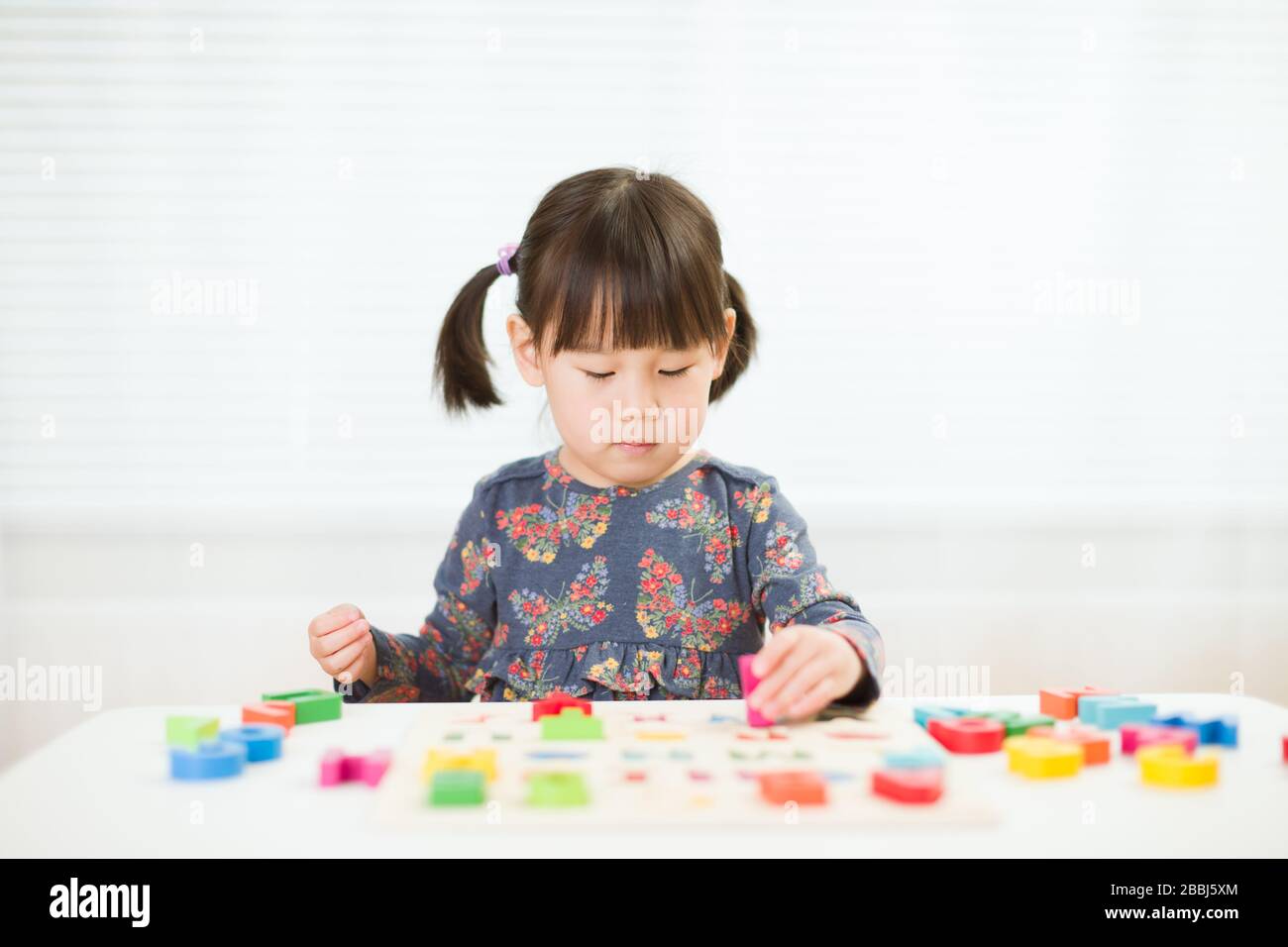 toddler girl learning letter blocks for homeschooling Stock Photo - Alamy