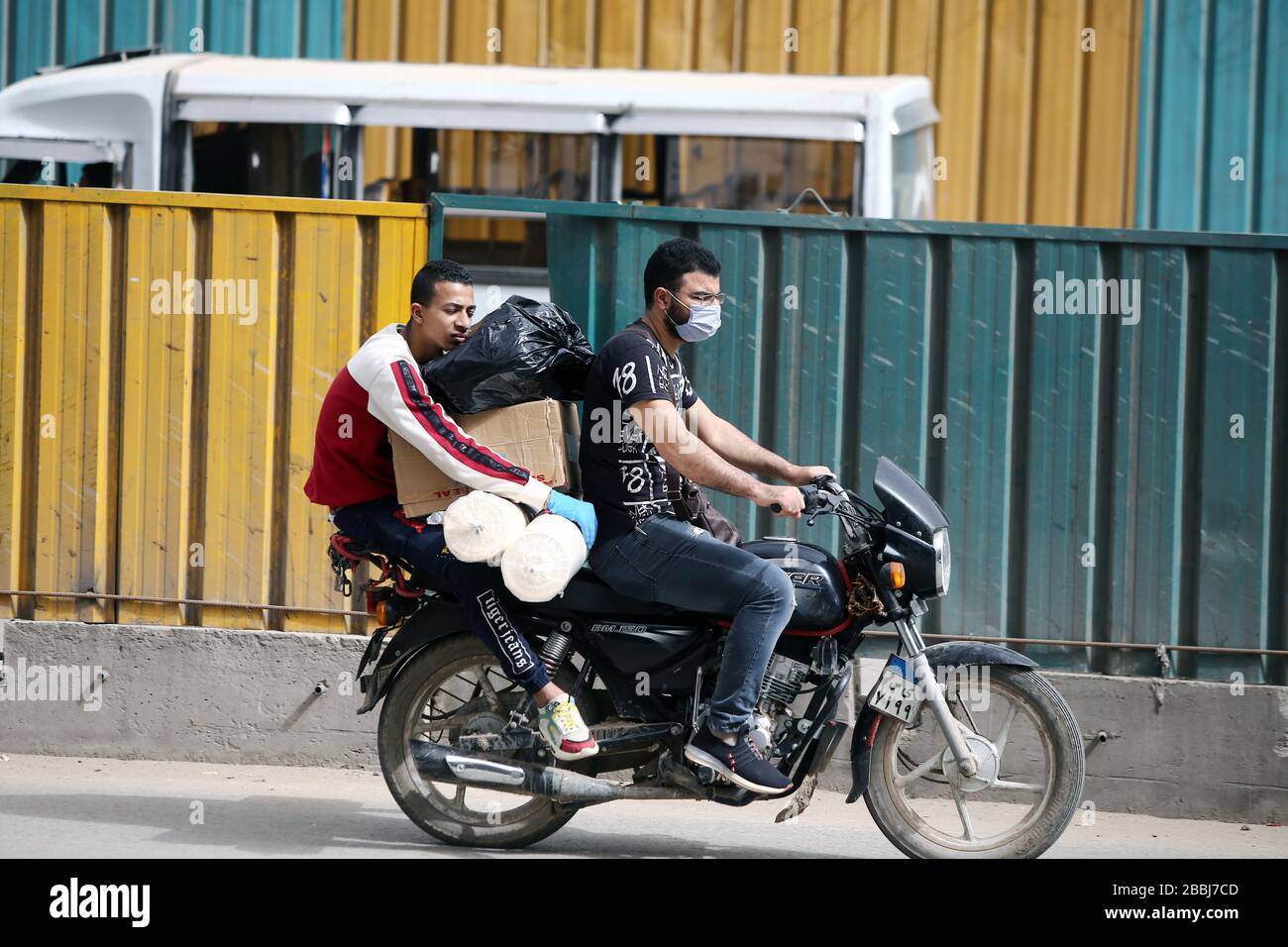 Cairo, Egypt. 31st Mar, 2020. A man wearing a face mask rides a ...