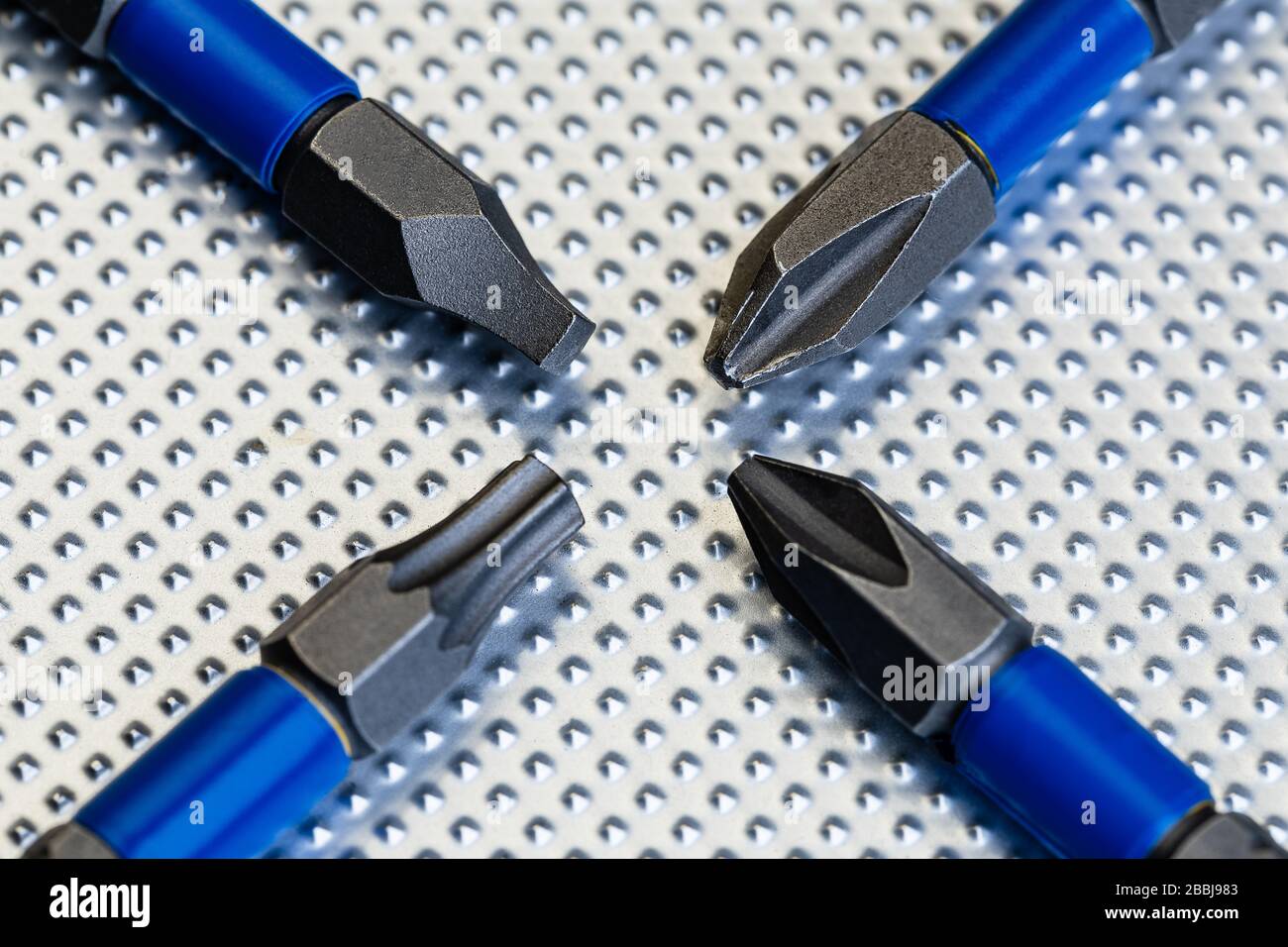 A macro image of 4 drill driver bits, 2 phillips head, a star driver ...