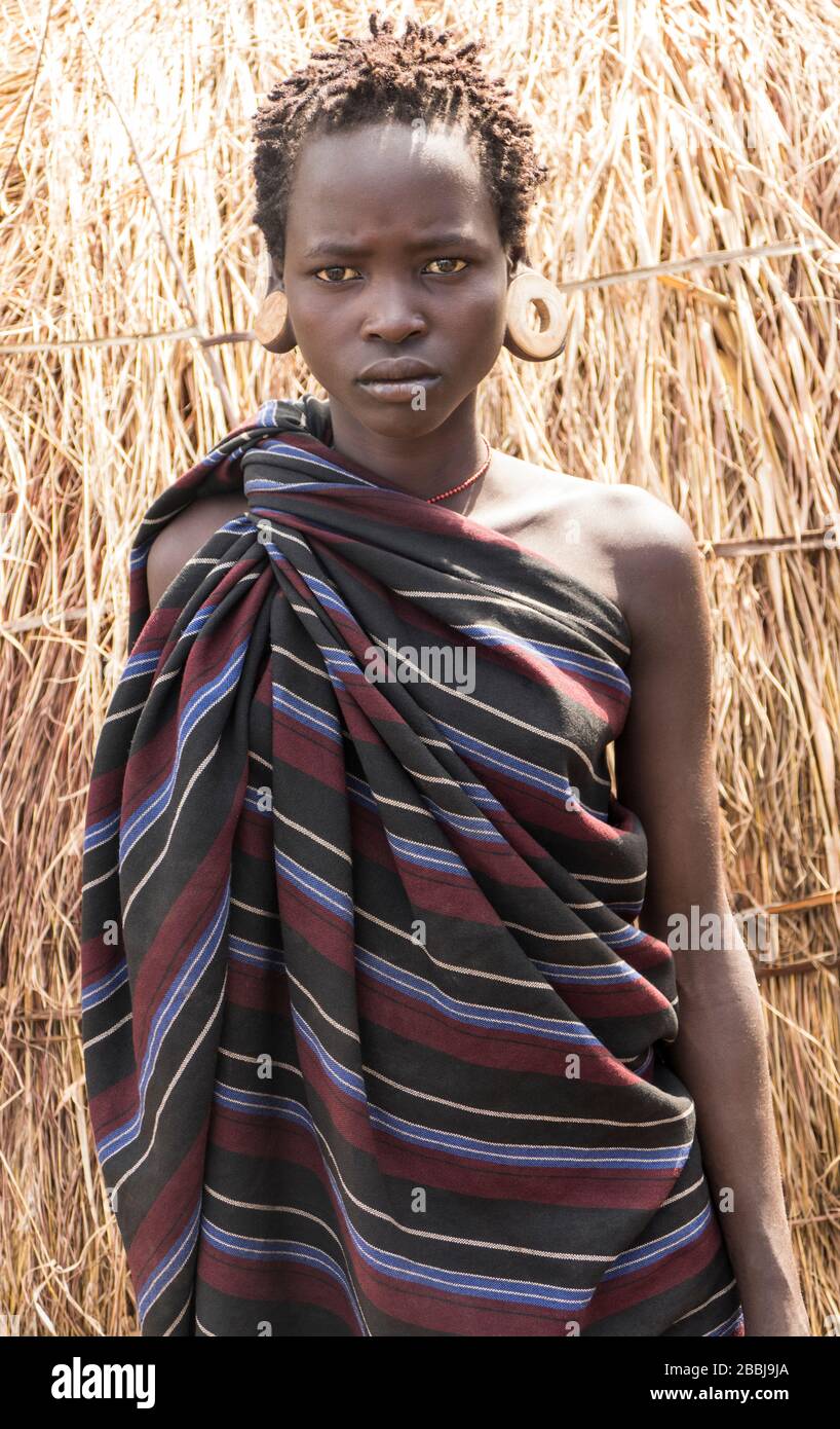 A Traditional Young Mursi Tribe Woman With Decorative Wooden Plates In Her Ear Lobes In The