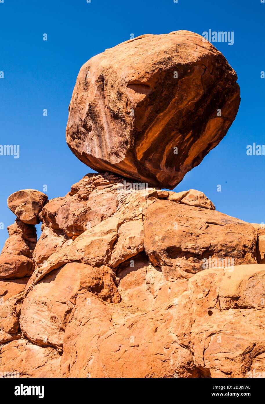 A large boulder leaning precariously on a slanted rock formation in The ...