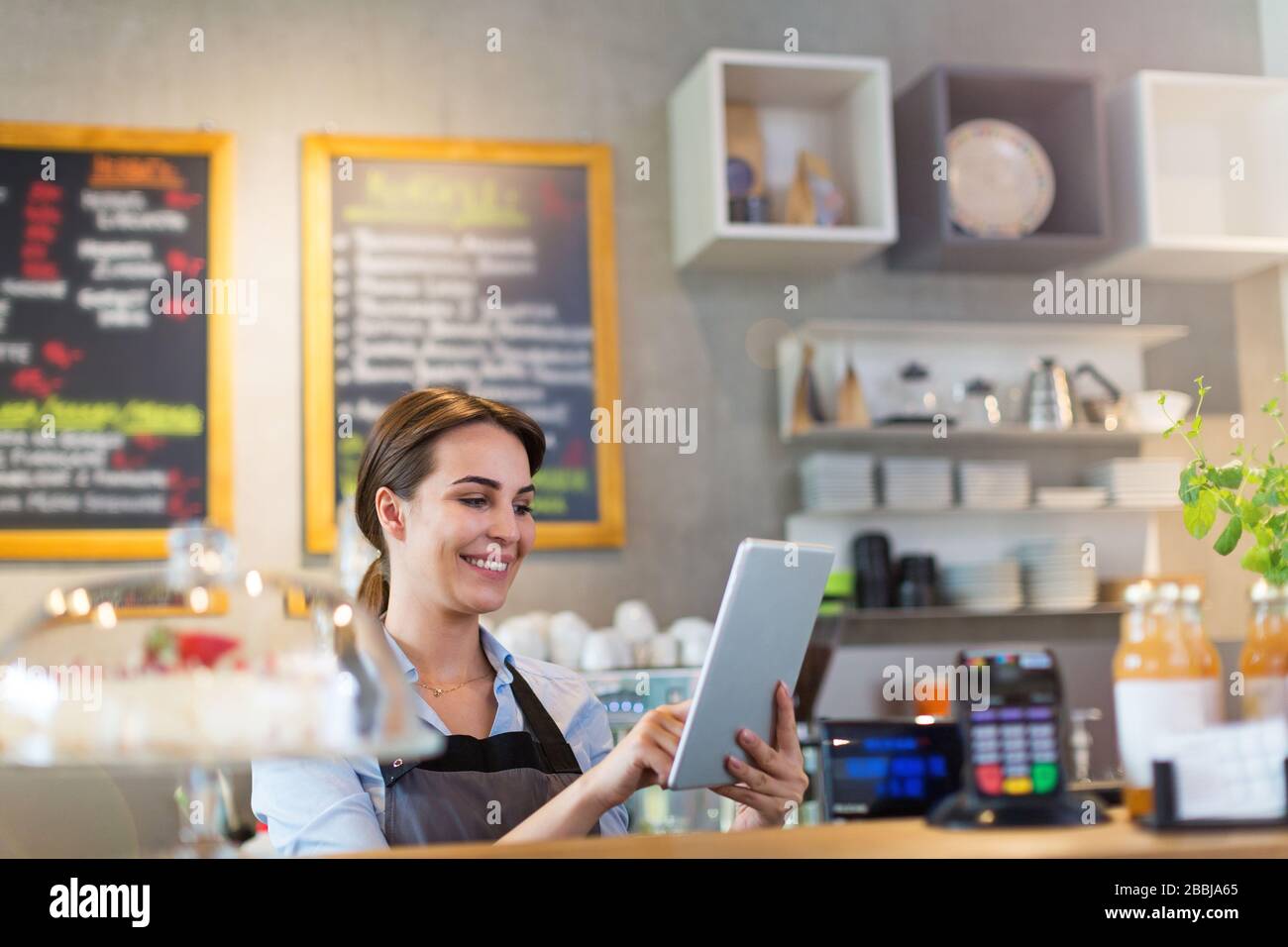 Woman working in coffee shop Stock Photo - Alamy
