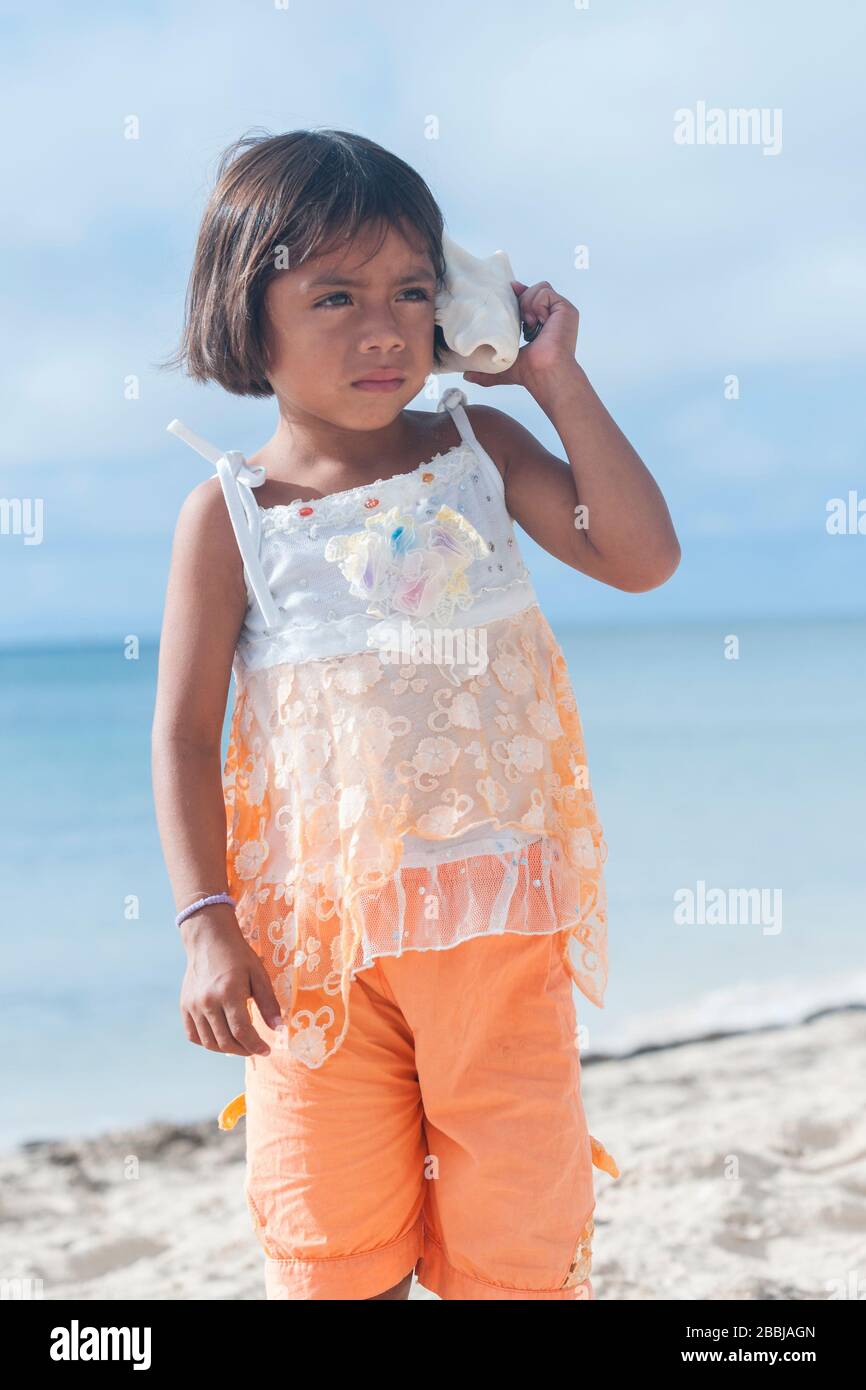 Girl holding shell to ear hi-res stock photography and images - Alamy