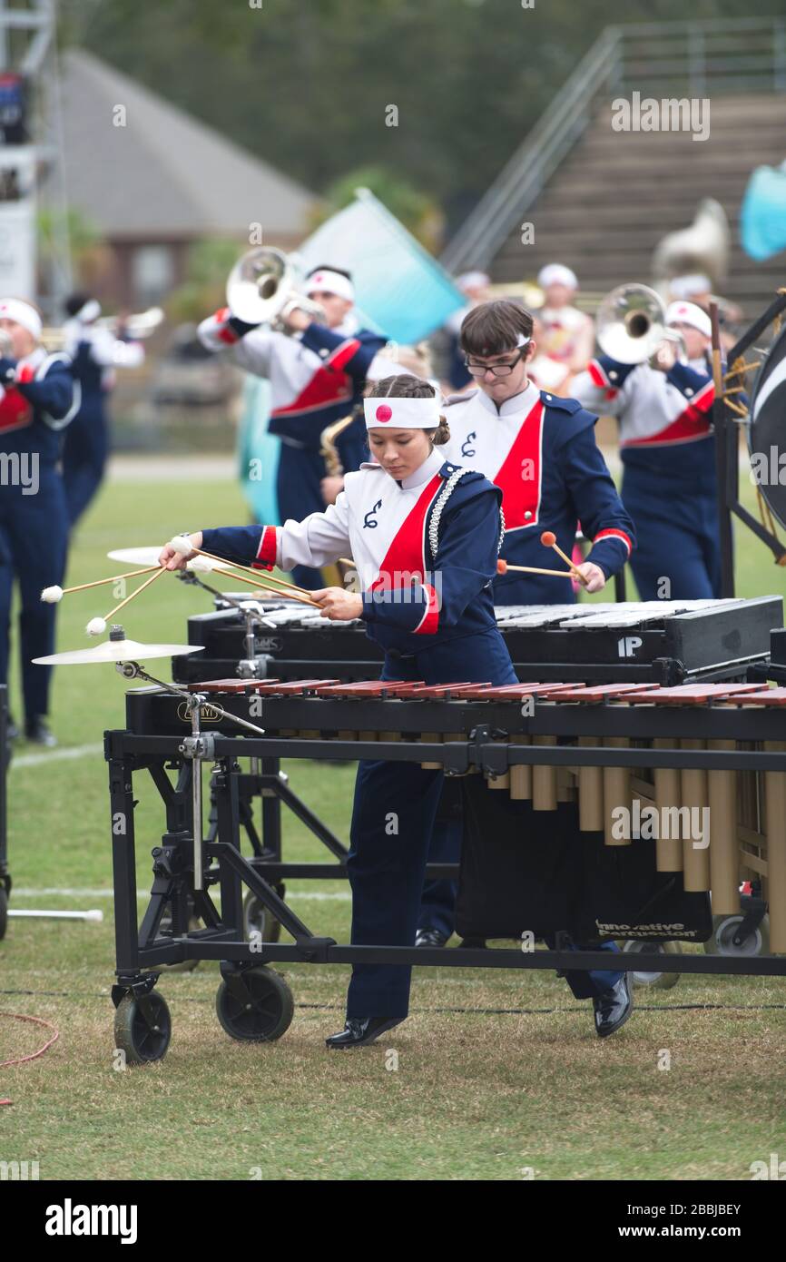Asian American teenage girl plays the marimba in a high school marching ...
