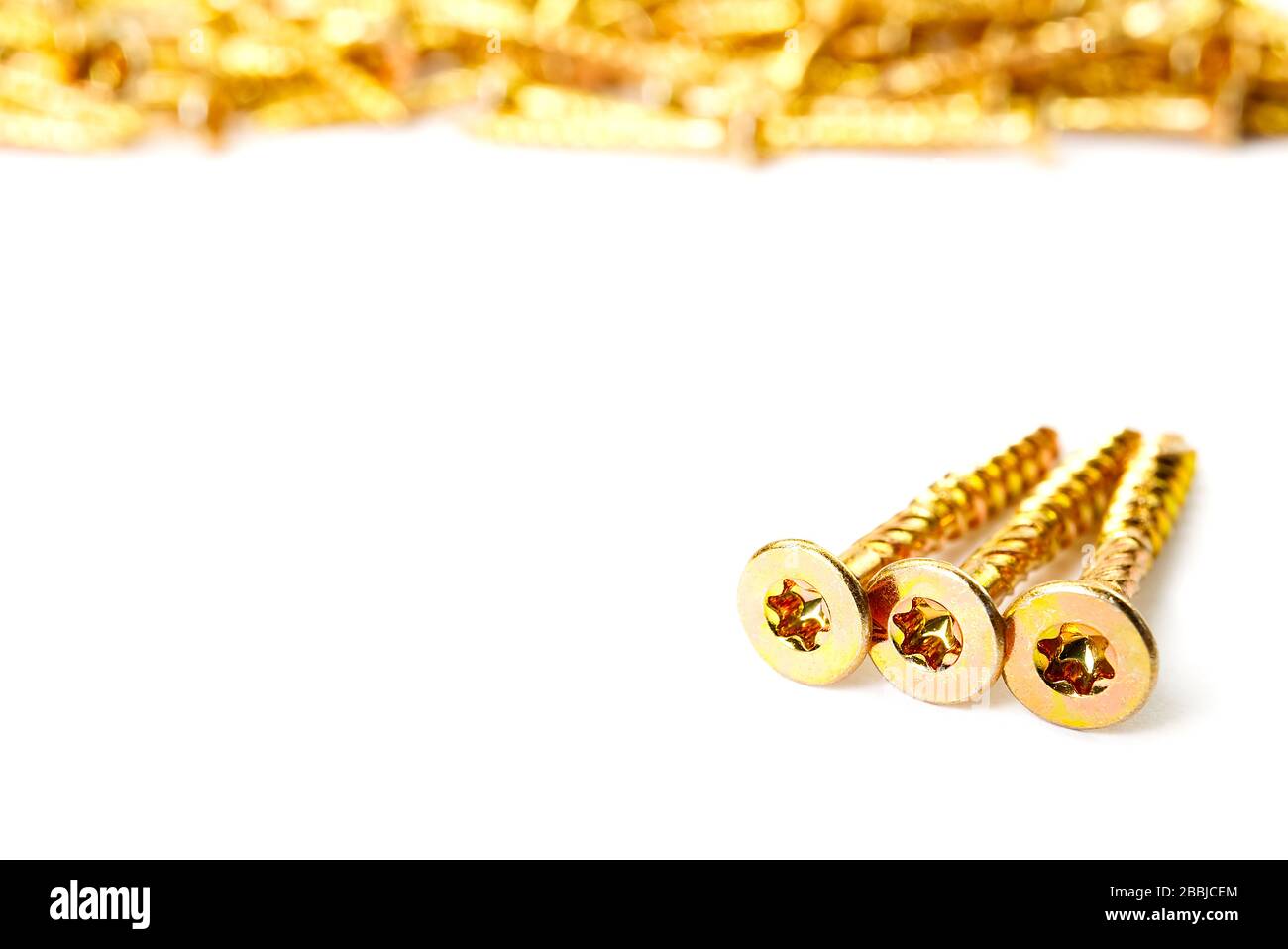 Gold screws scattered randomly on a white background. Torx yellow zinc ...