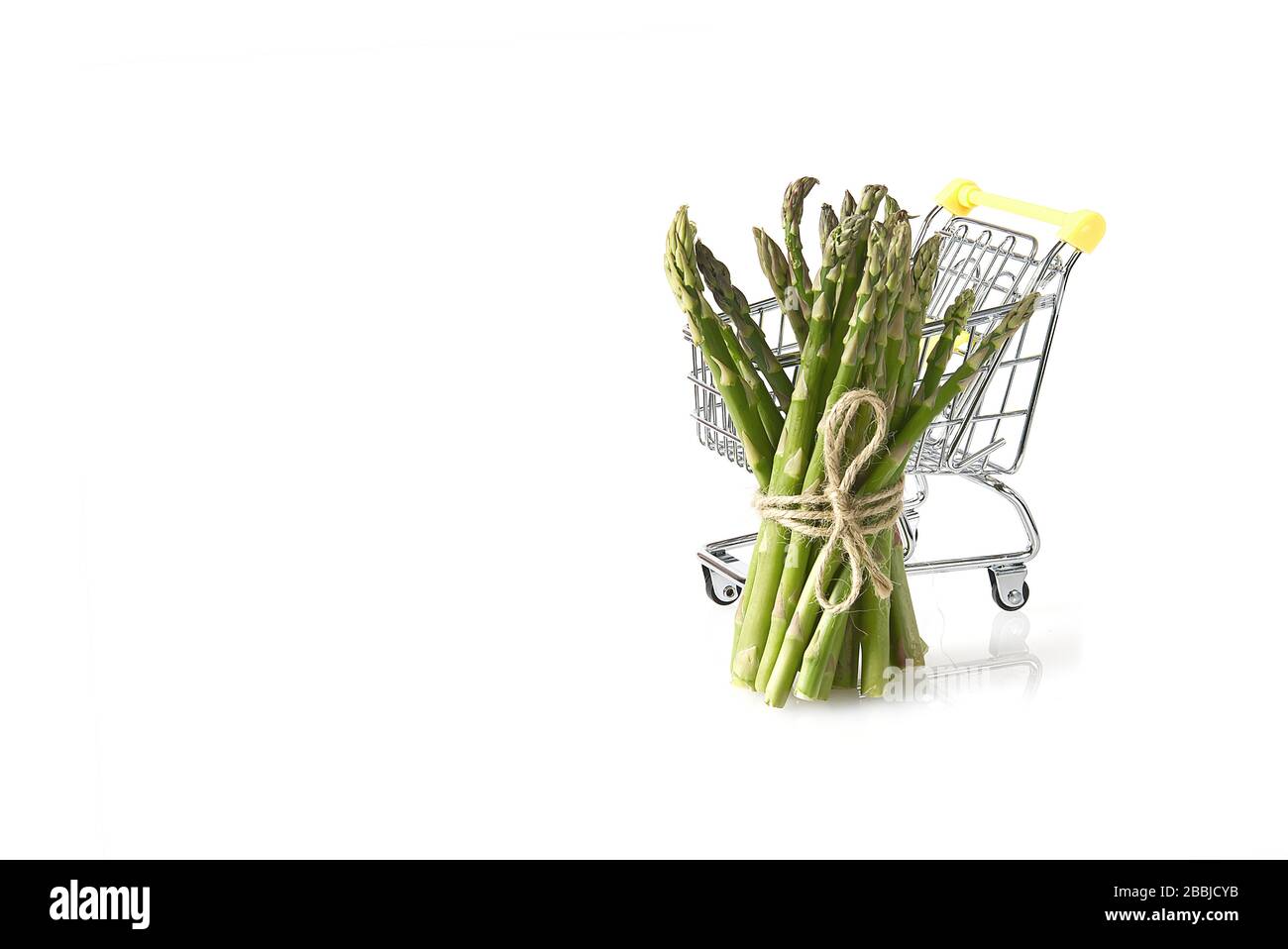 Fresh green asparagus in shopping cart isolated on white background ...