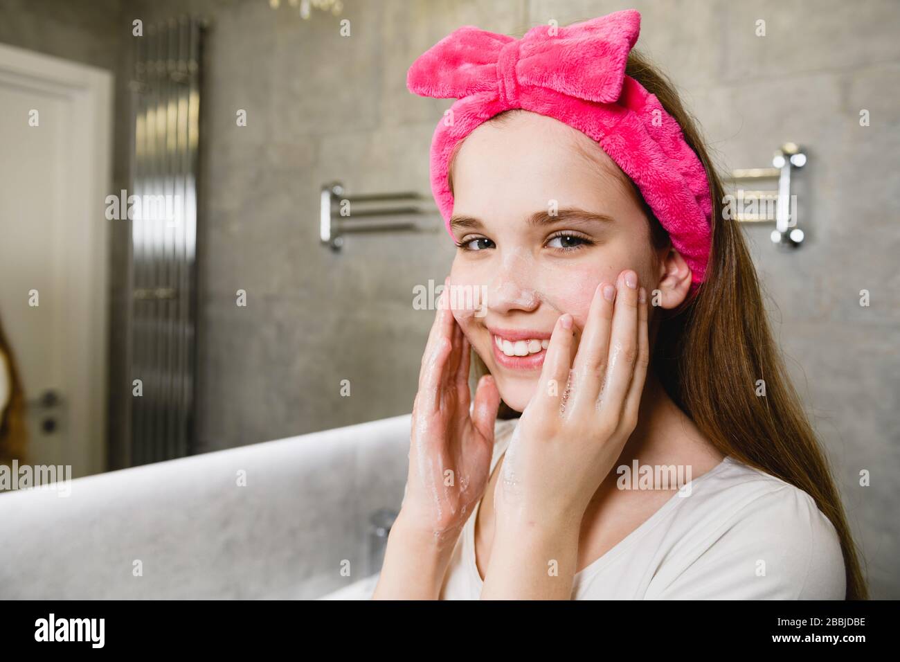 Teen girl wash face with soap foam Stock Photo - Alamy