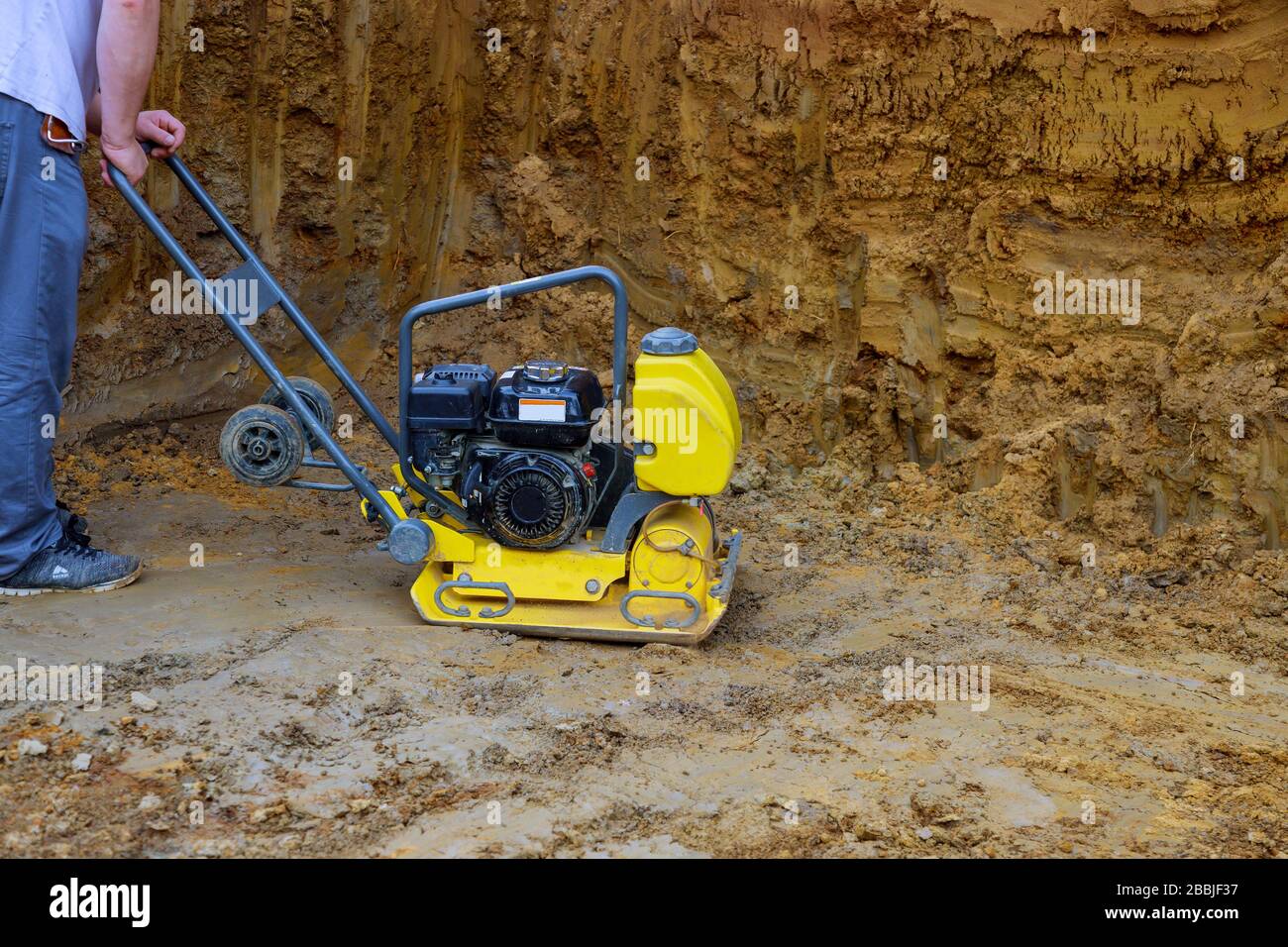 Working tool compresses in rammer area around building with foundation ...