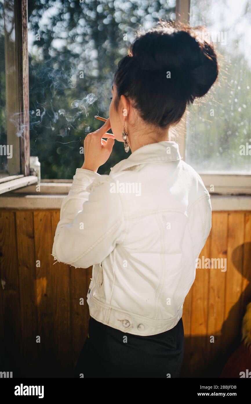 smoking woman on the balcony standing with her back Stock Photo - Alamy