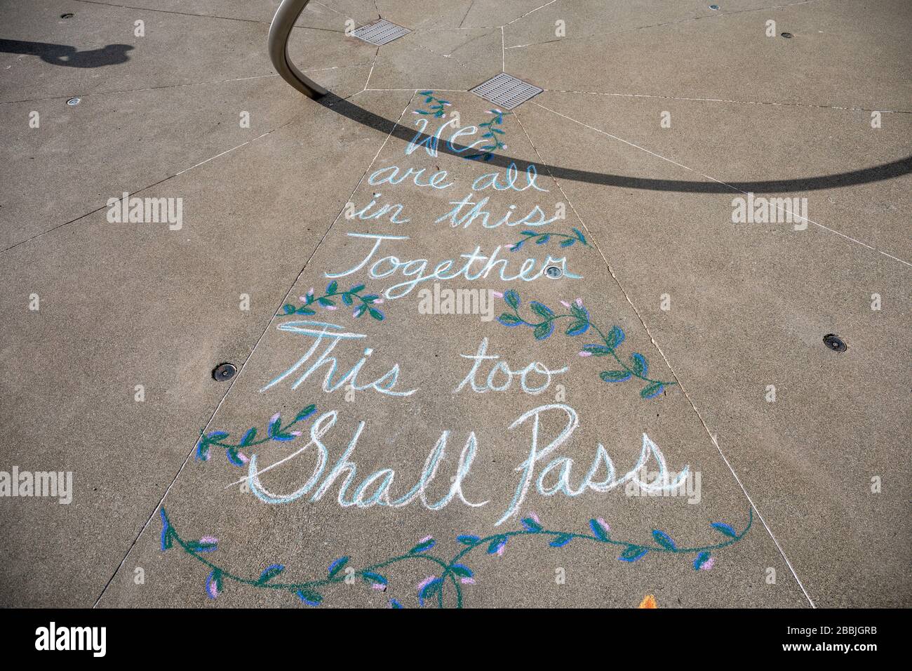 An inspirational message is written in sidewalk chalk on the cement ...