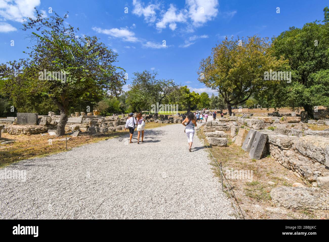 Tourists including three young women, walk the gravel path through the ...