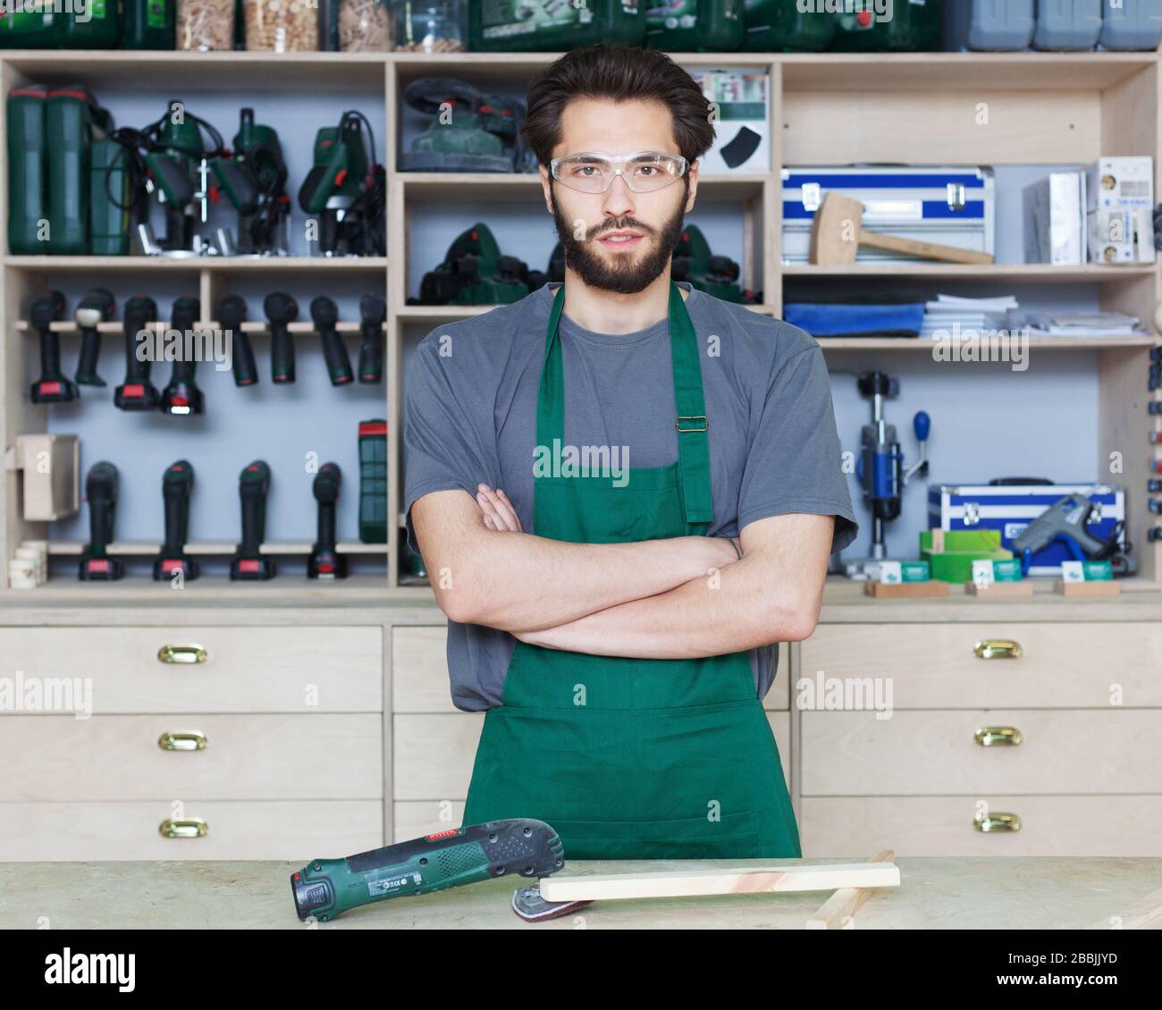Carpenter master with a beard in work clothes in a carpenter's workshop ...