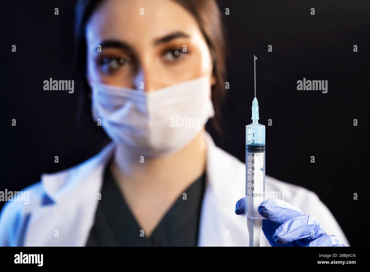 Caucasian white Doctor or nurse woman with mask and blue examination ...