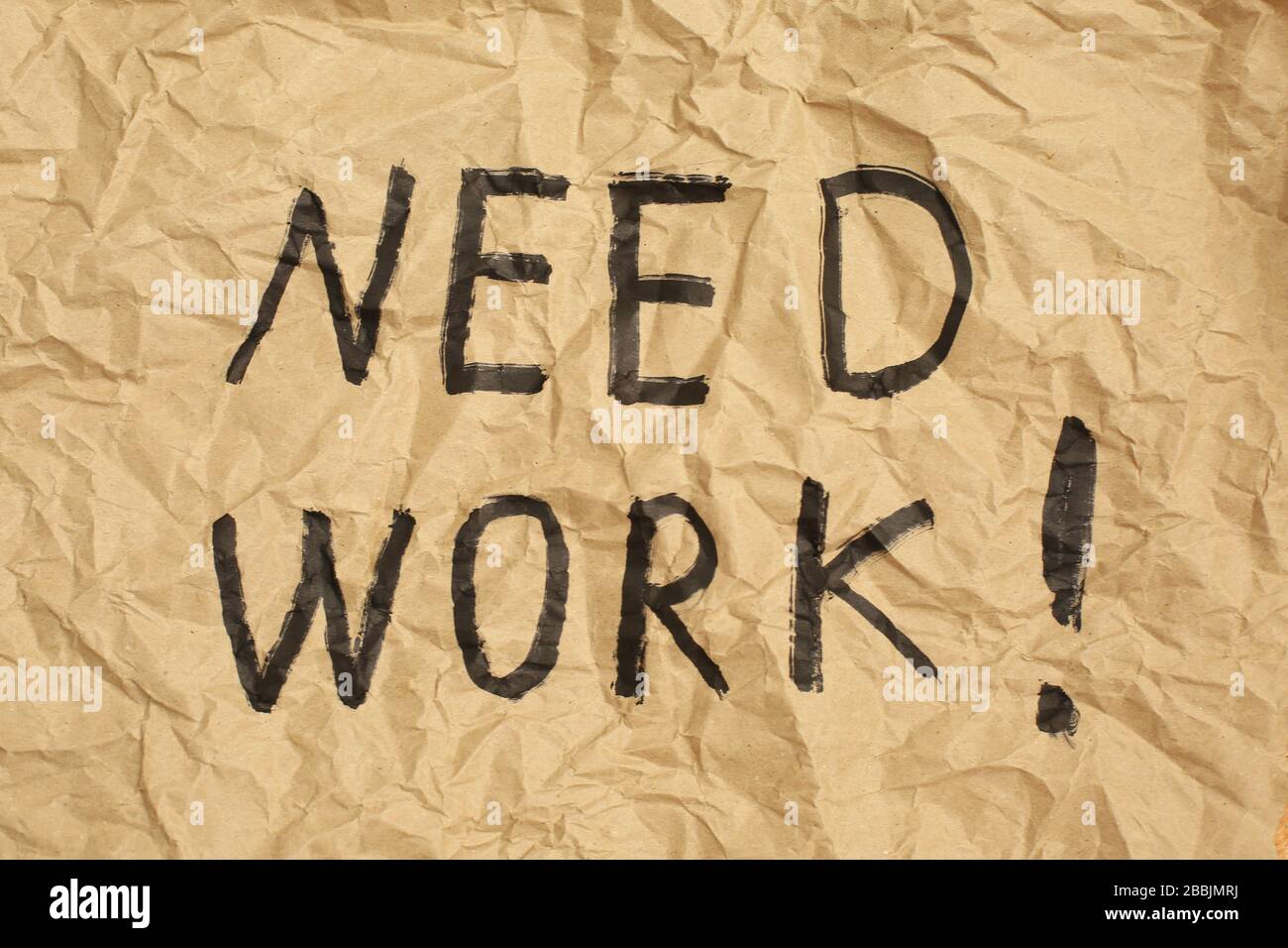 NEED WORK sign on Crumpled brown recycled paper background Stock Photo ...
