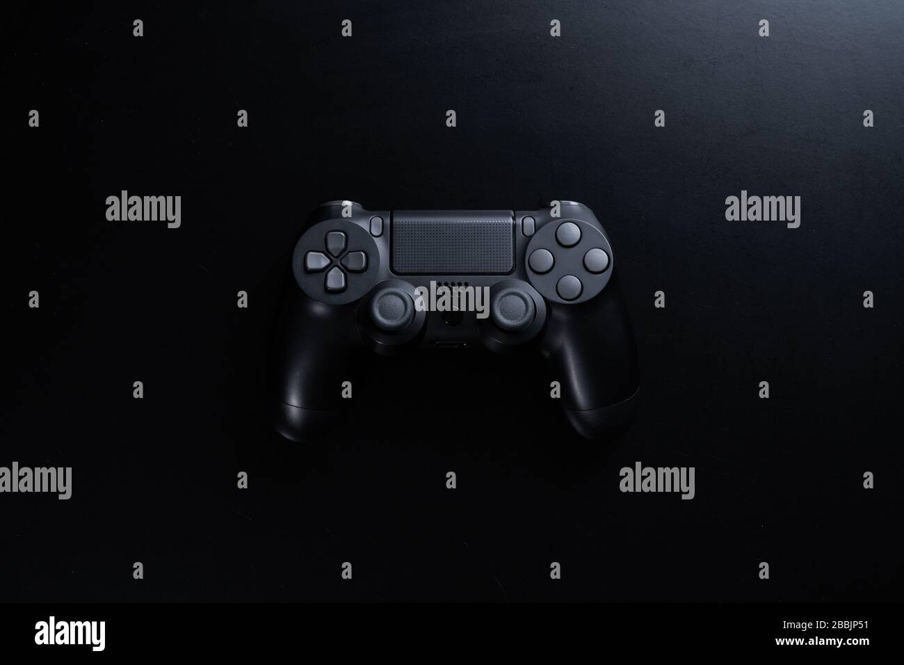 A black game controller isolated on black background Stock Photo - Alamy