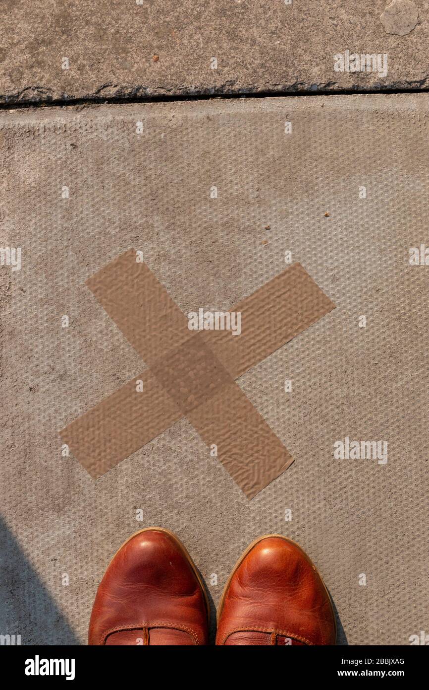 A close up view of taped off area on where to stand waiting to get into ...