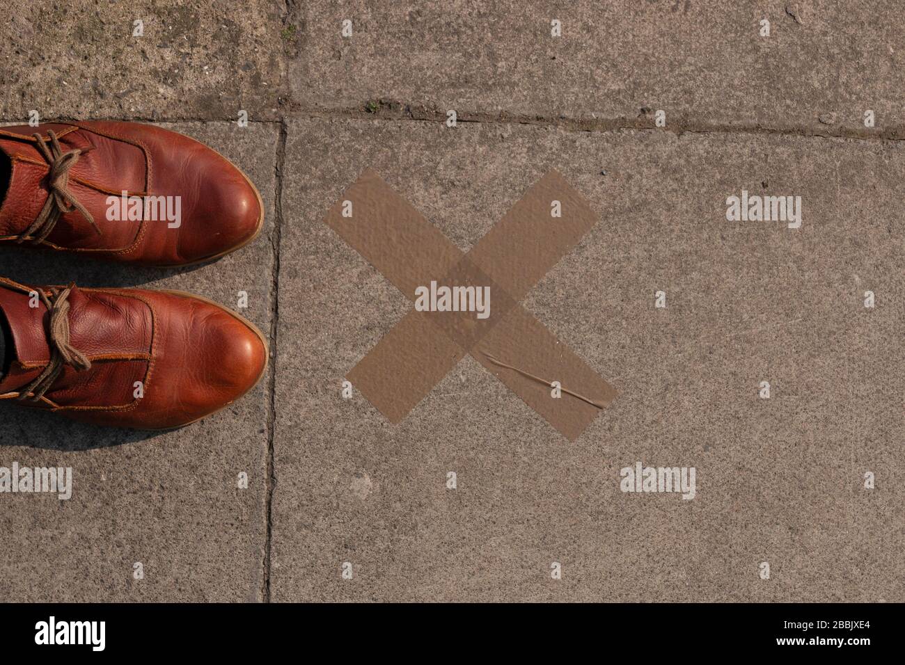 A close up view of taped off area on where to stand waiting to get into ...