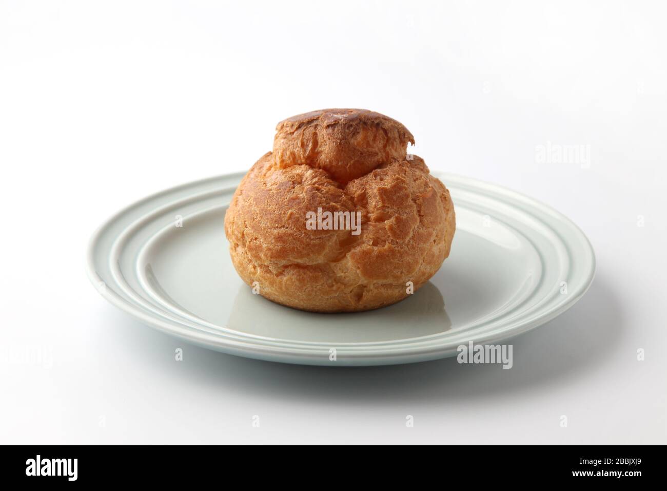 cream puff on plate closeup isolated on white background Stock Photo ...