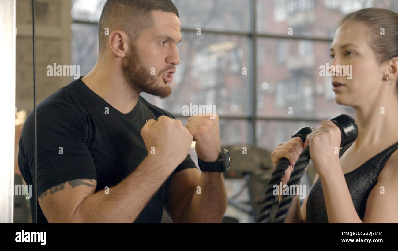 Instructor yelling at woman while working out in gym Stock Photo - Alamy