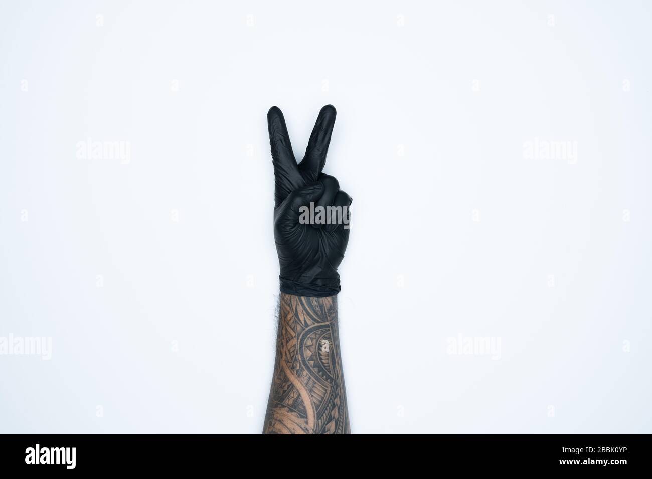 A man hand and gestures in Black rubber glove shows two sign isolated ...
