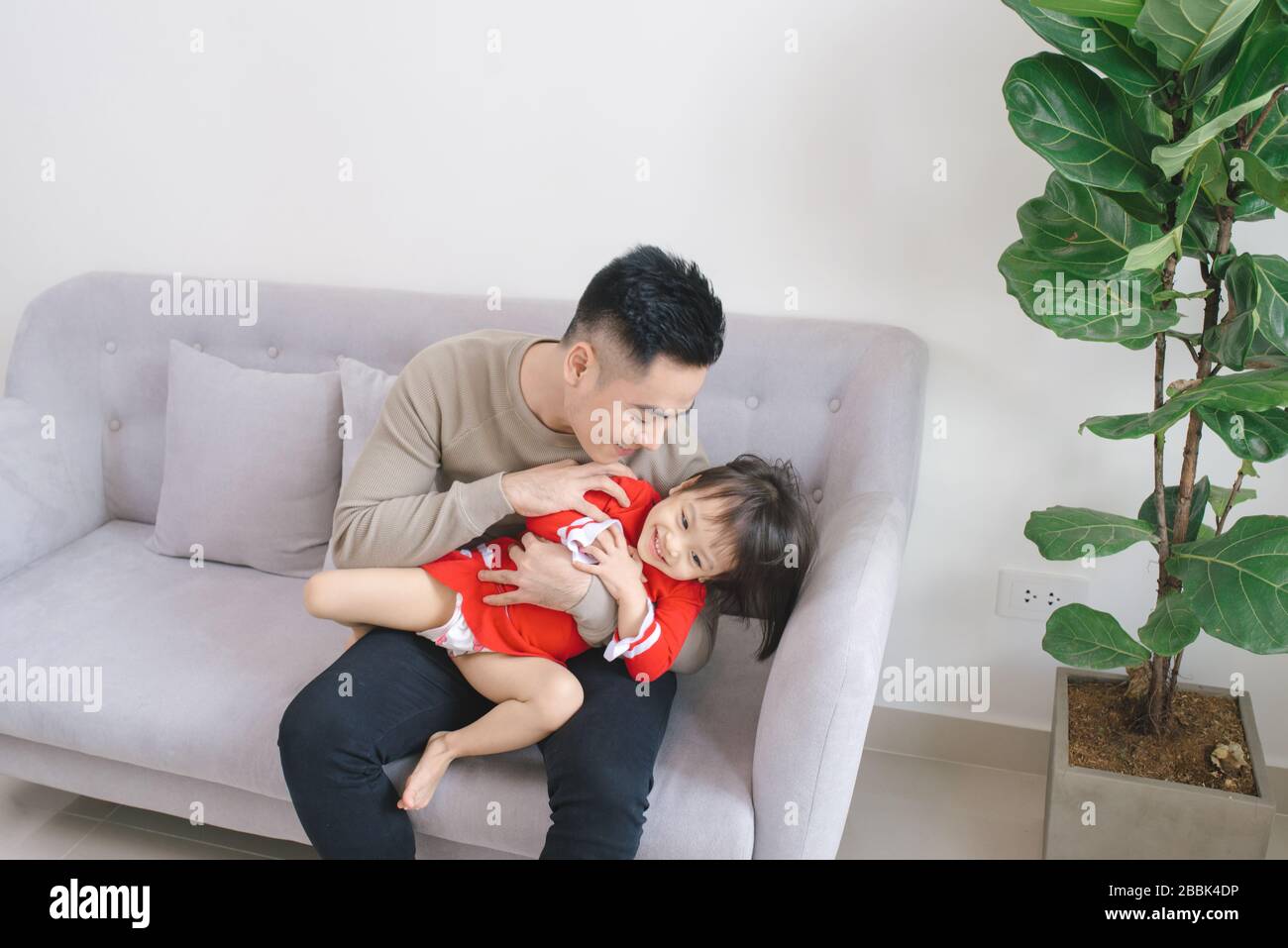 Dad and his daughter hugging while sitting on sofa Stock Photo - Alamy