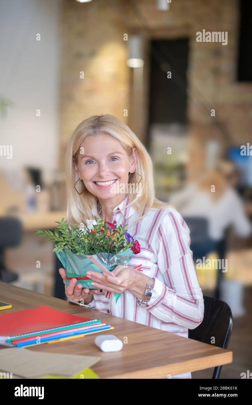 Blonde woman receiving bouquet of flowers, feeling excited Stock Photo ...