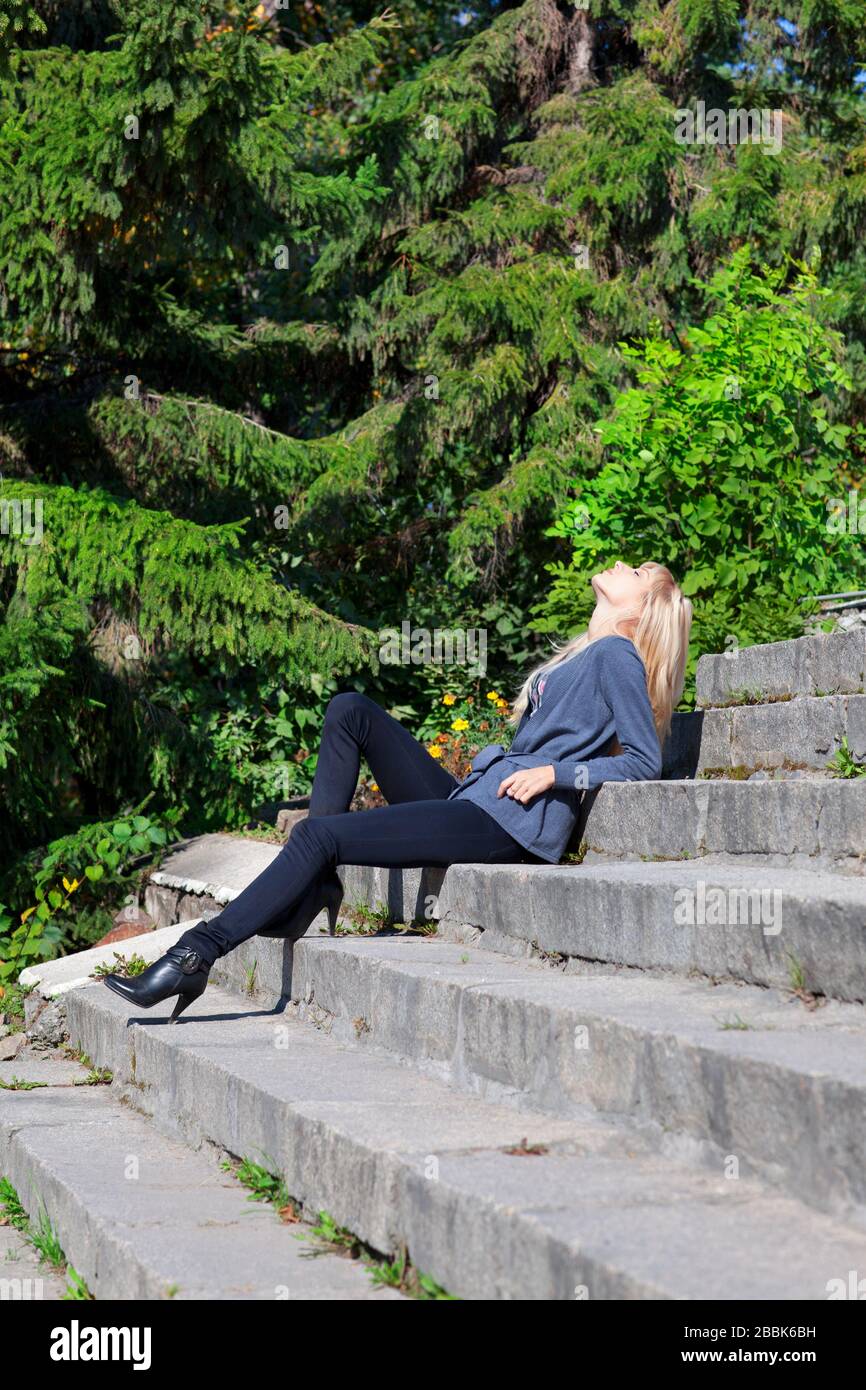 Beautiful young girl sitting on stone steps Stock Photo - Alamy