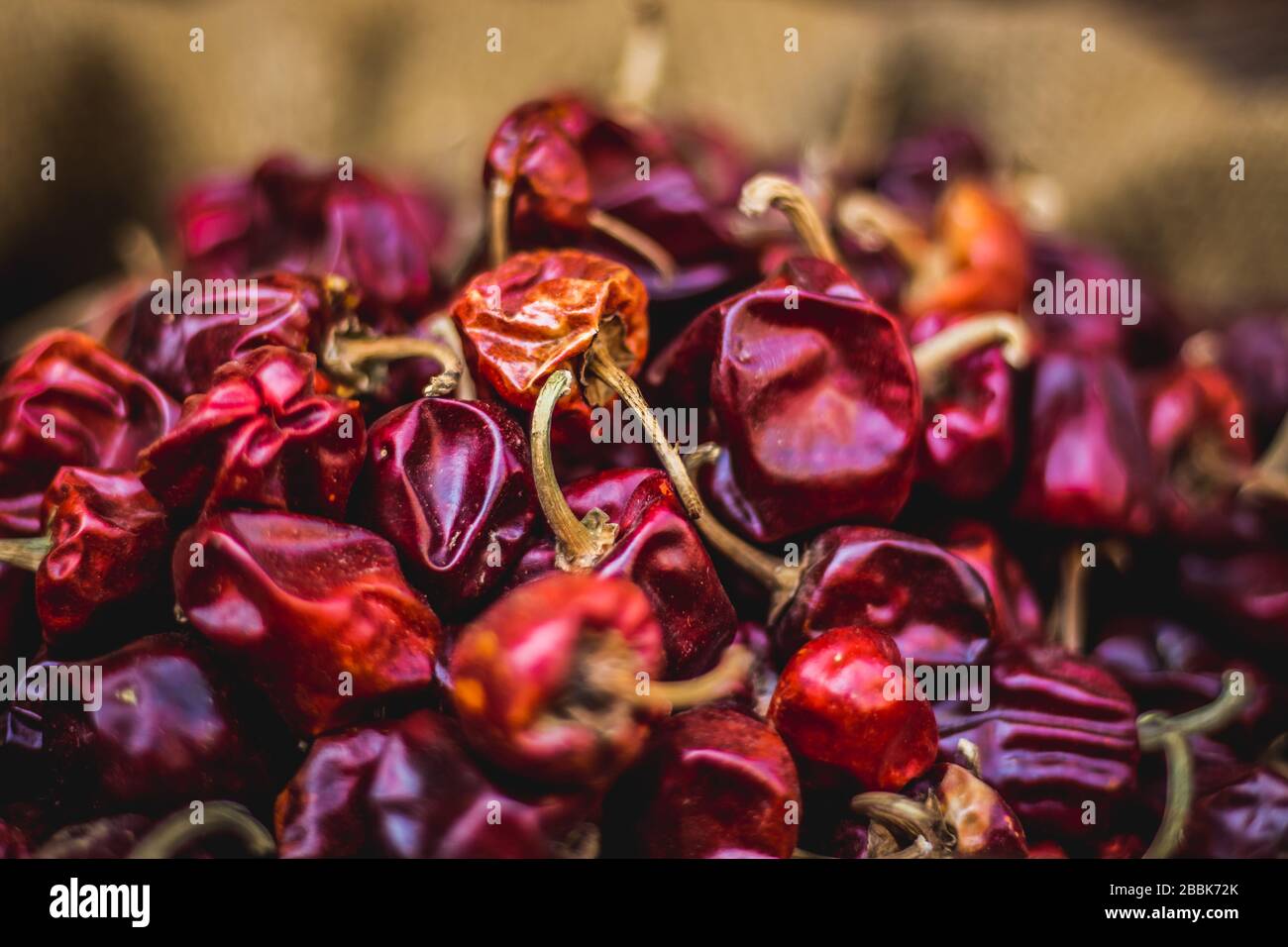 Dried red chilli peppers. Close up shot of spicy red chilli on red ...