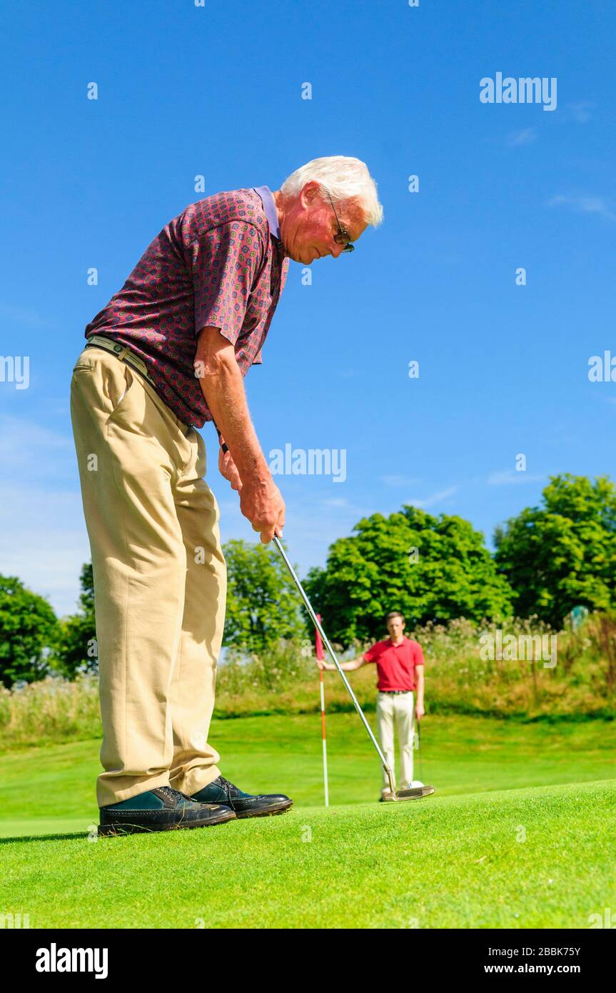 Young and old man playing golf Stock Photo - Alamy