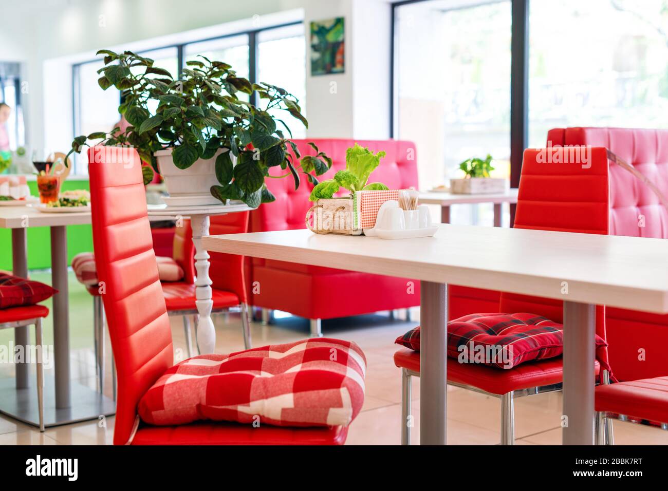 Modern design restaurant interior in white and red colors with plants ...