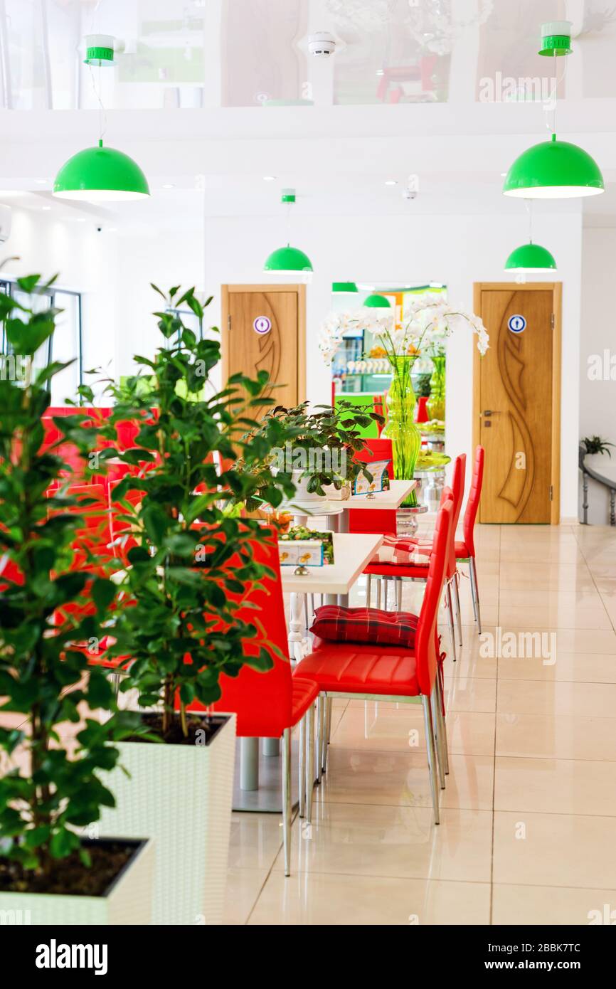 Modern design restaurant interior in white and red colors with plants ...