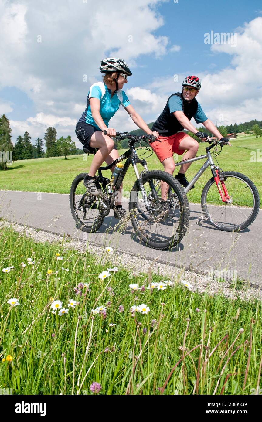 Young people doing cycling tour in green nature of Allgäu Stock Photo ...
