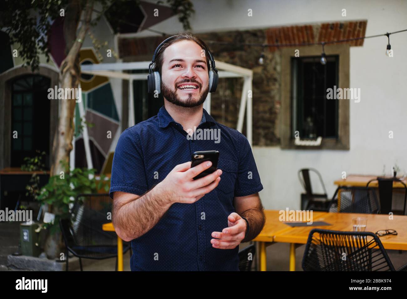 Mexican Man in headphones listening music with his smartphone in Mexico ...