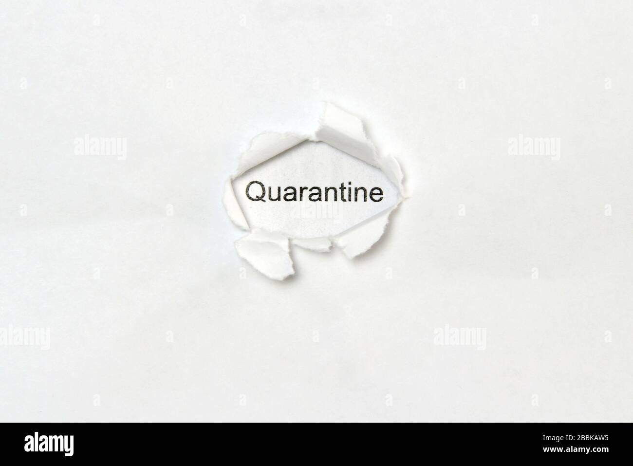 The word quarantine printed in black letters on a white sheet of paper ...