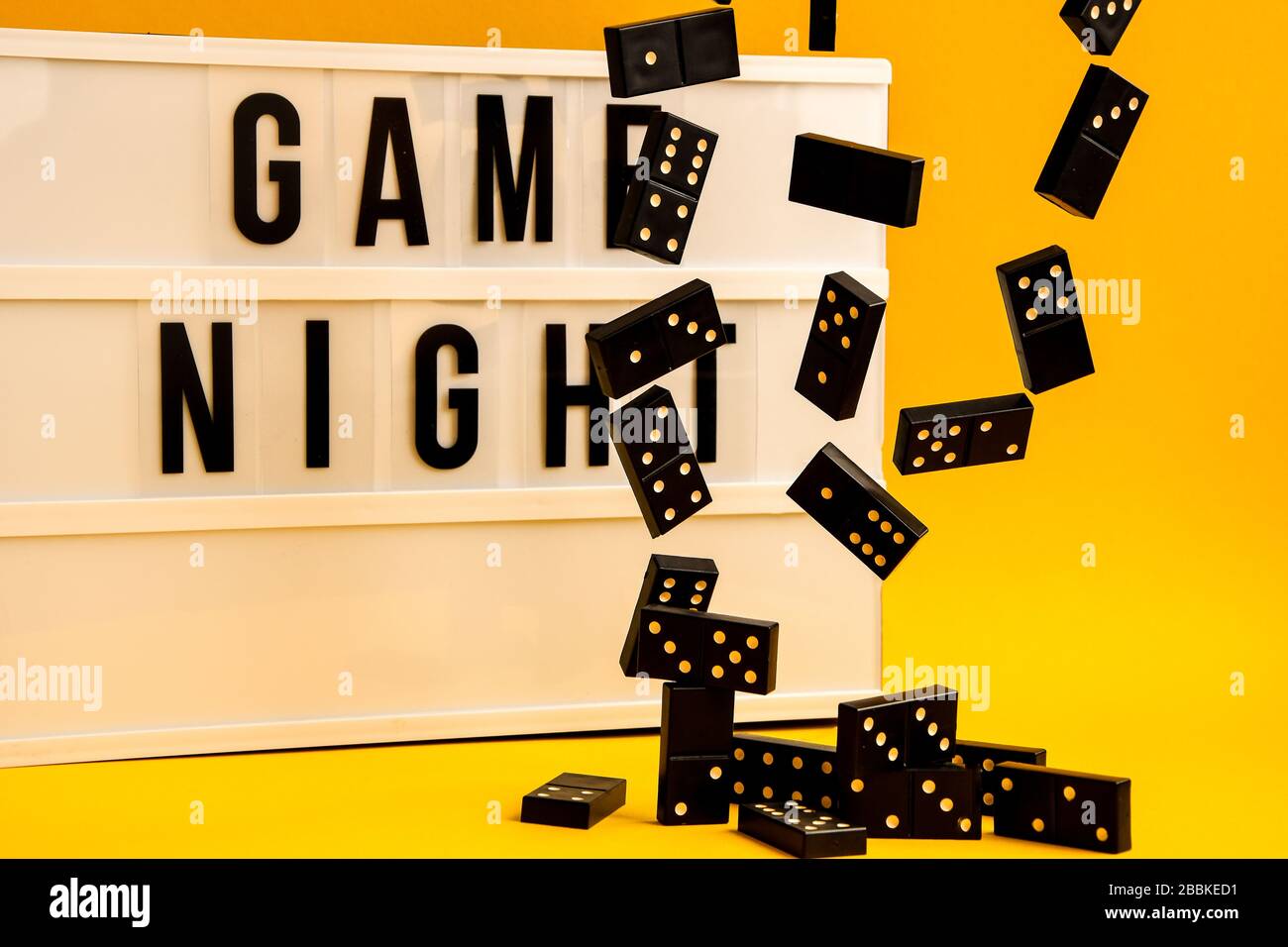 Game night text on lightbox with black dominoes on yellow background ...