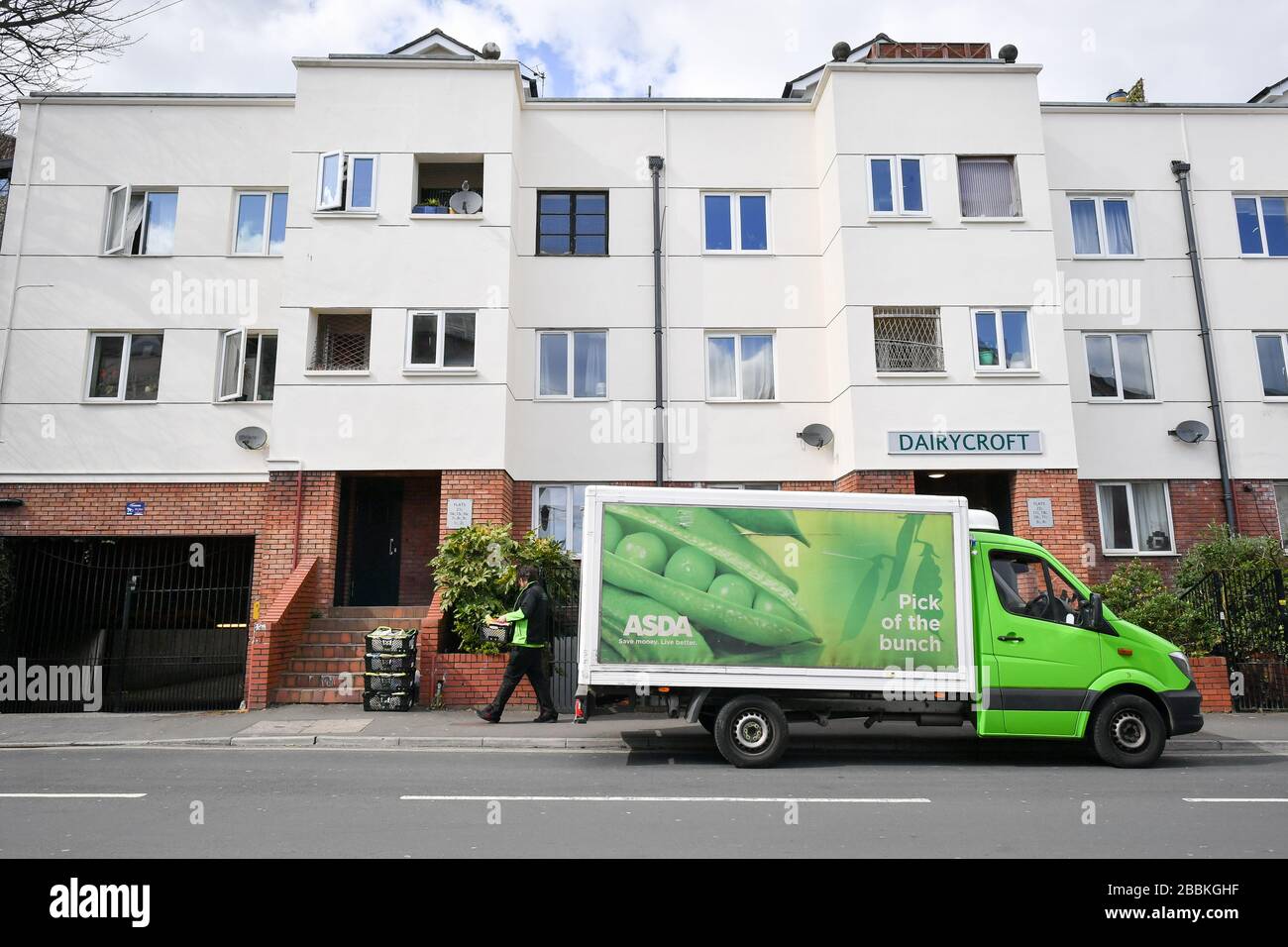 An ASDA delivery driver stacks food baskets during his rounds in ...