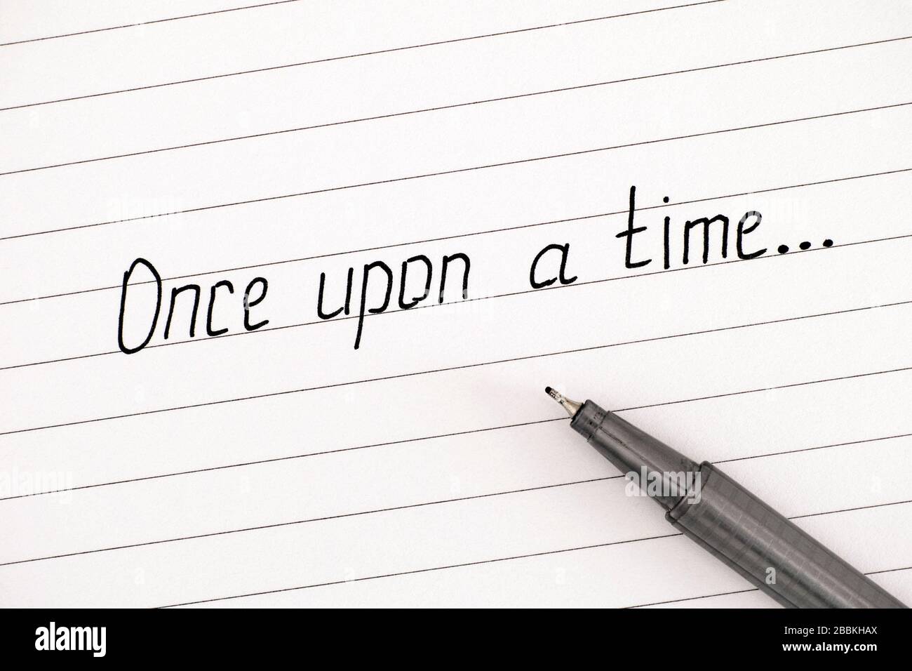 Handwriting text Once Upon a Time on lined paper with pen. Close-up ...