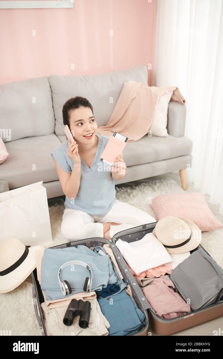 Tourist talking on phone, booking hotel and holding passport, ticket ...