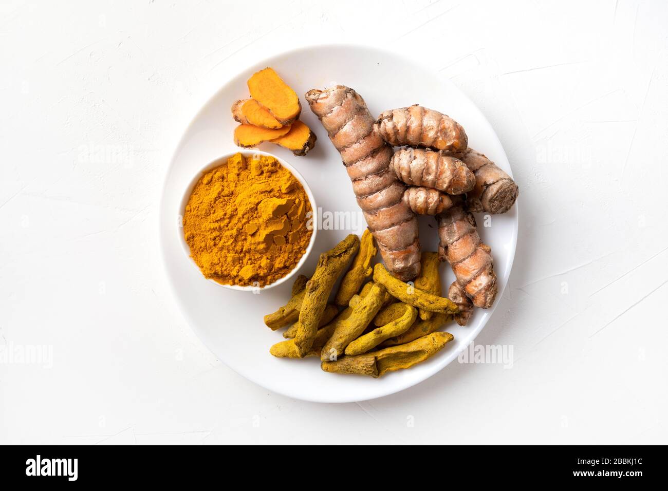 Fresh and dry root turmeric, curcuma powder in dish on white background ...