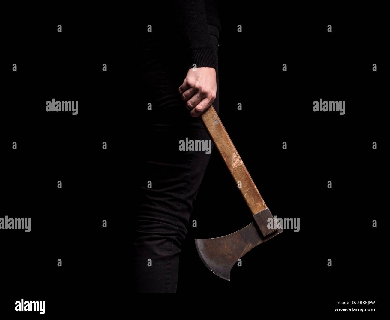 Girl holding in hand throwing axe on black background Stock Photo - Alamy
