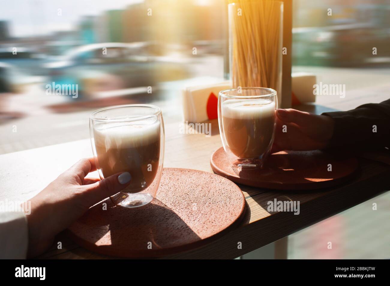 Young women are keeping cups of coffee. Female models take a drink in ...