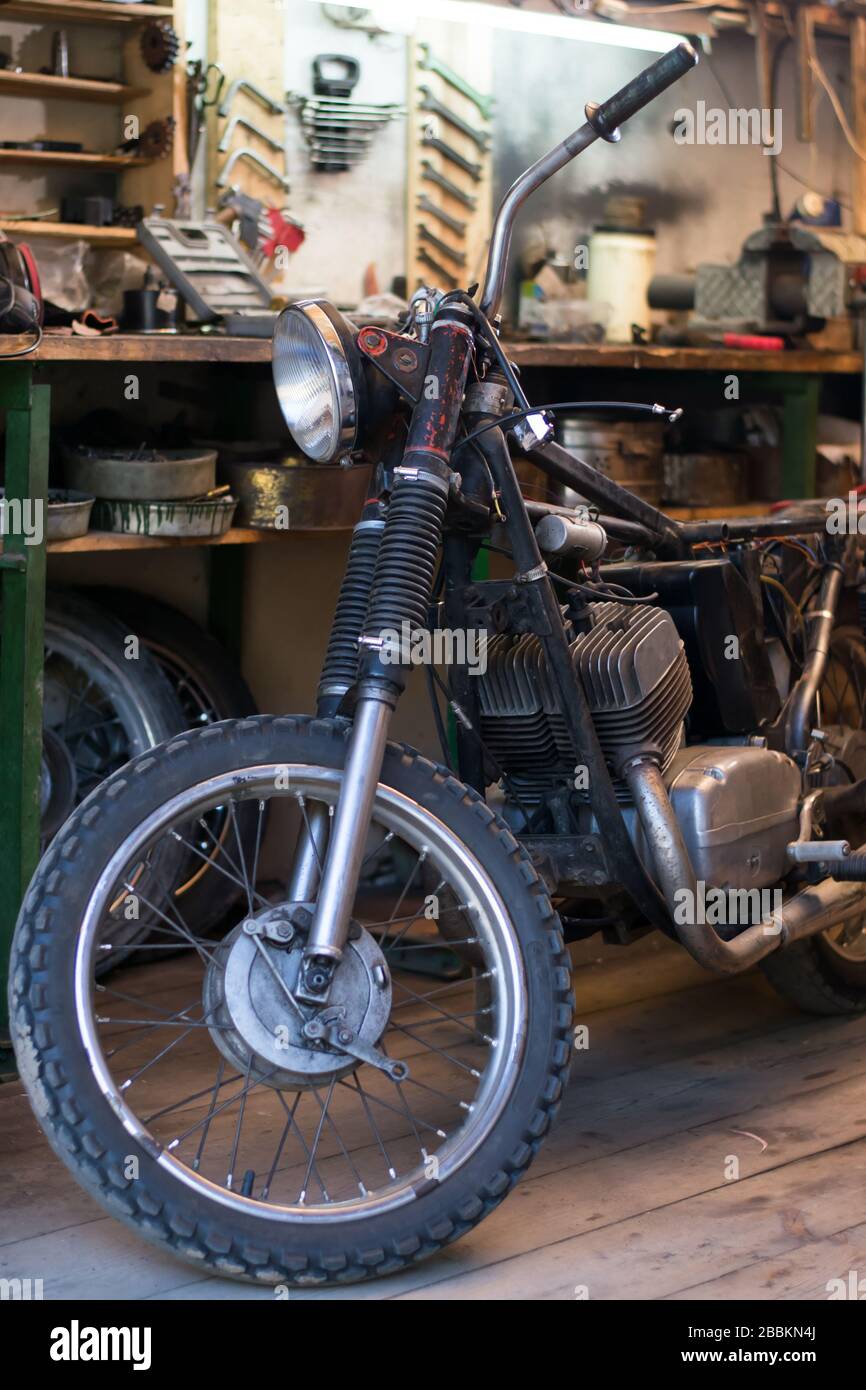 Old motorcycle, which needs to be repaired, in the workshop Stock Photo ...