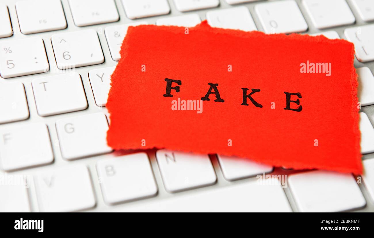 Word Fake written on torn paper on a computer keyboard Stock Photo - Alamy