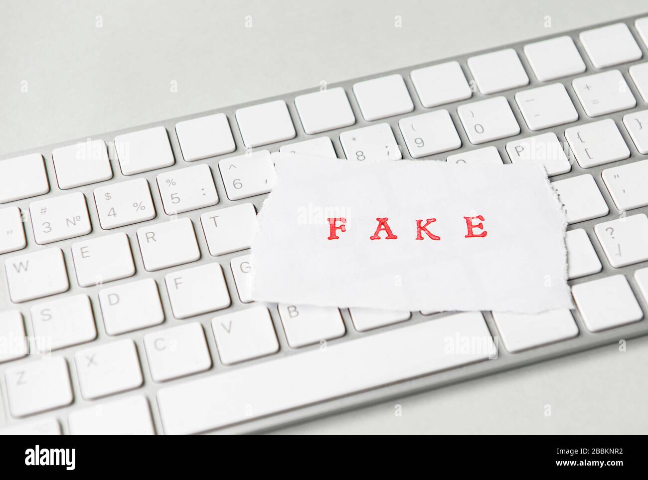Word Fake written on torn paper on a computer keyboard Stock Photo - Alamy