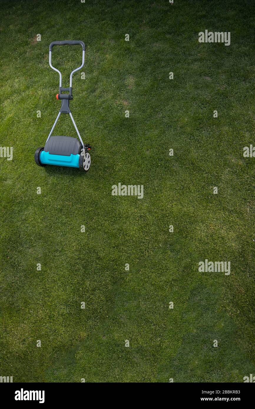 Lawnmover hand held machine. Hand lawn mower. Lawn mower on a green ...