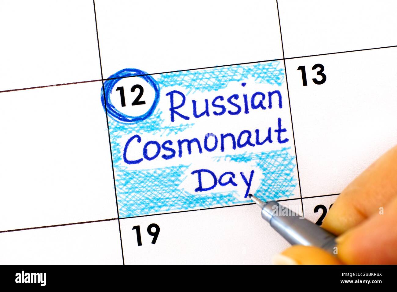 Woman fingers with pen writing reminder Russian Cosmonaut Day in ...