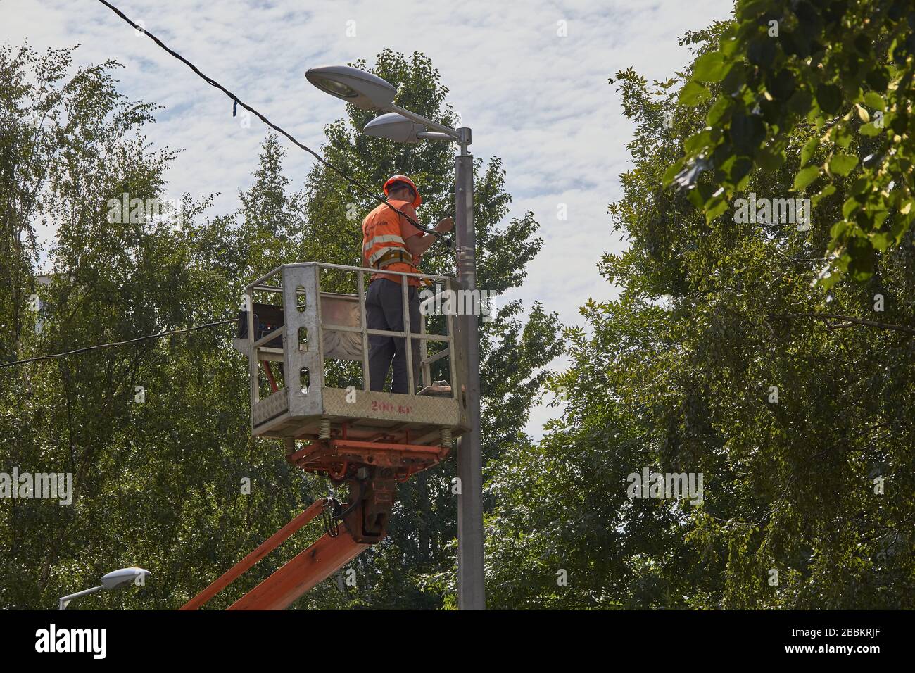 Saint Petersburg, RUSSIA - July 11, 2019: workers in lift bucket repair ...