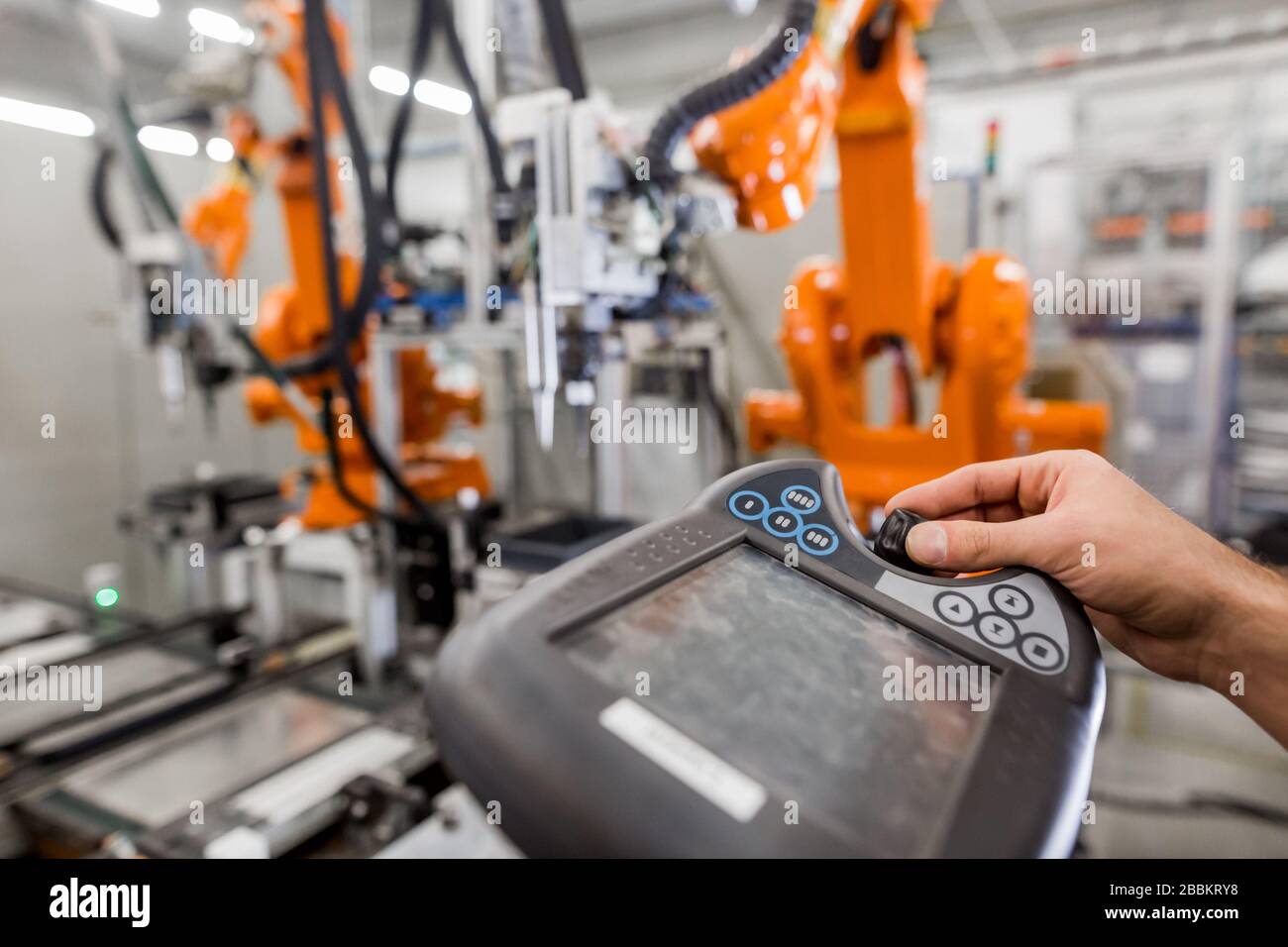 Technician man programming robot in automotive industrial, professional ...