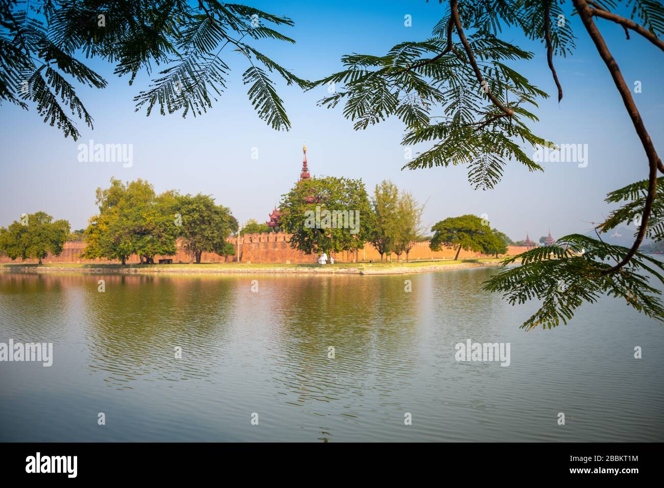View through trees to Mandalay Palace (Mya Nan San Kyaw) outer ramparts ...