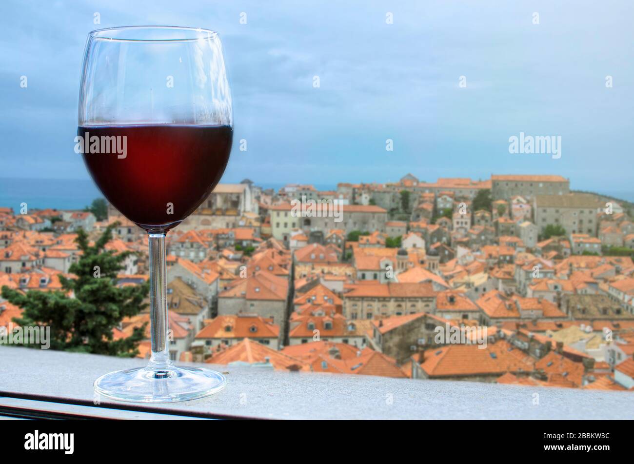 Glass of red wine with the view on reed rooftops of historic old ...